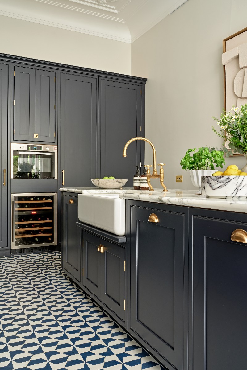 Dark blue kitchen design with marble surfaces and a curved island